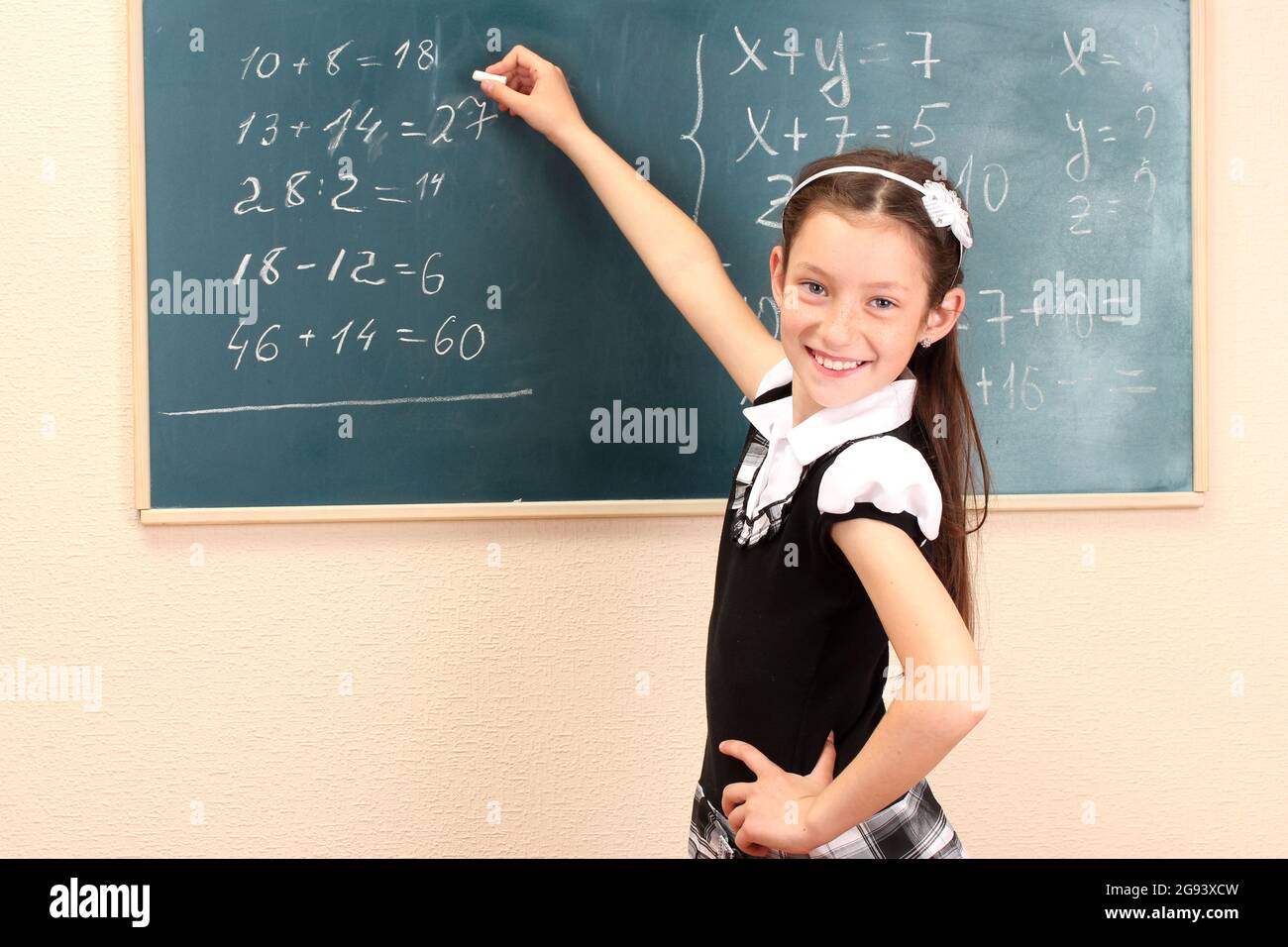 beautiful little girl writing on classroom board Stock Photo - Alamy
