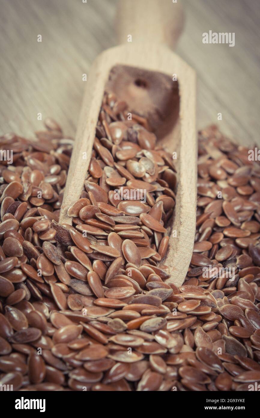 Heap of linseed with wooden spoon containing dietary fiber and natural ...