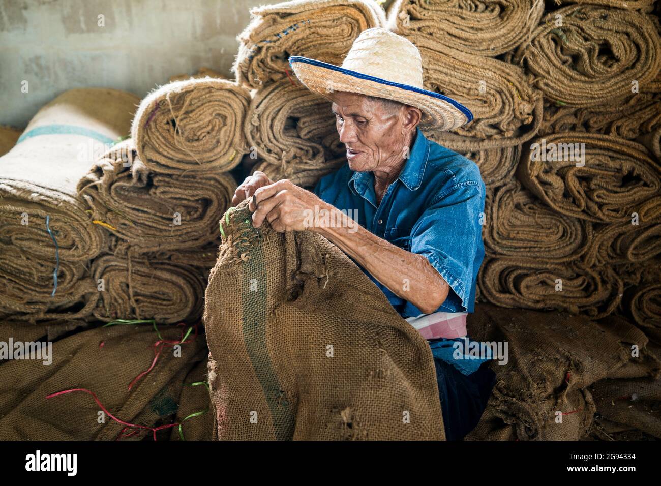 Old Asian man sewing sacks at the rice mill factory Stock Photo - Alamy