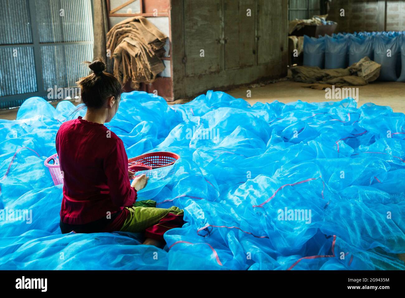 Young Asian woman sewing the fishnet at the fishing village Stock Photo ...