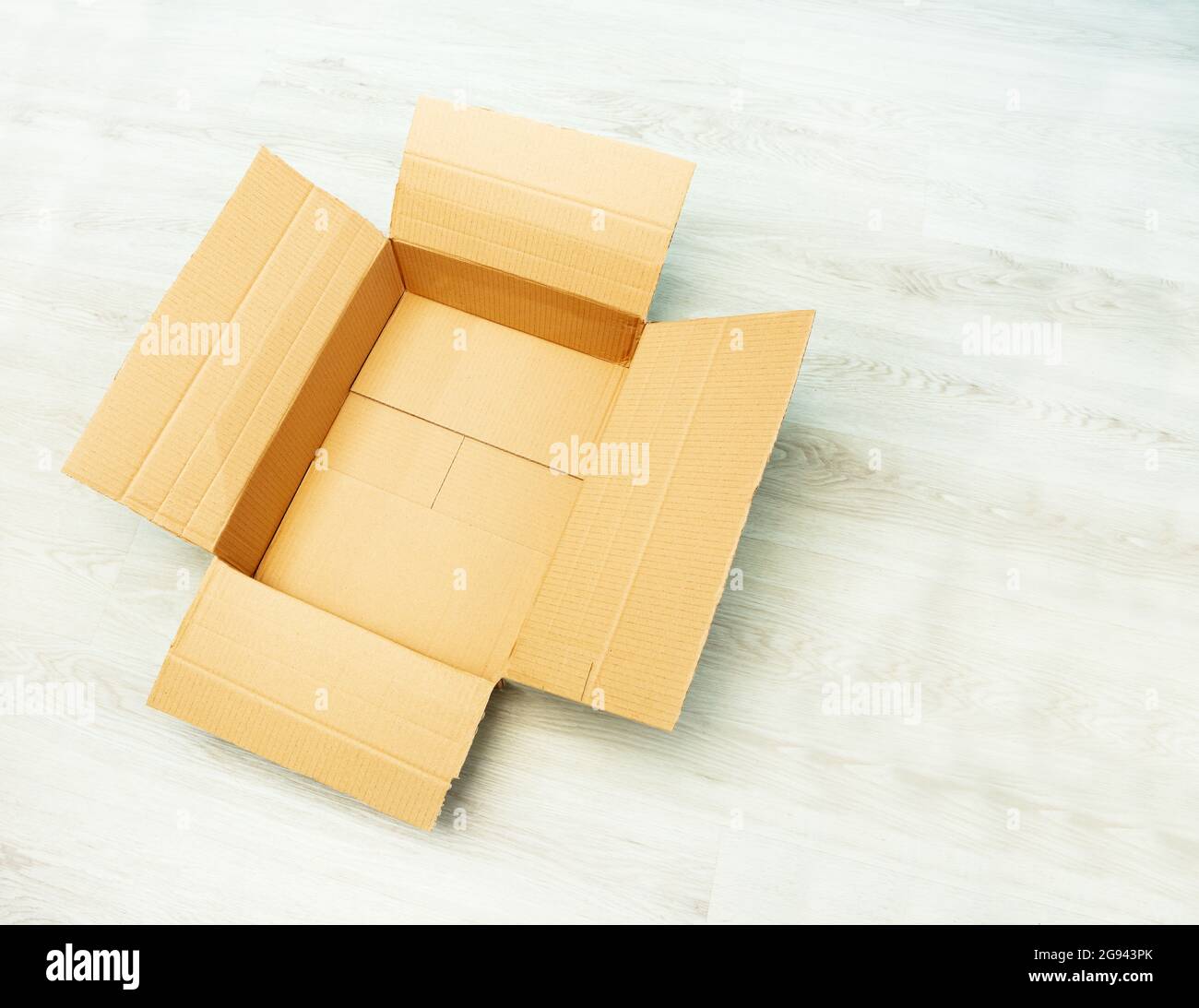 Empty open cardboard box on the parquet floor Stock Photo - Alamy