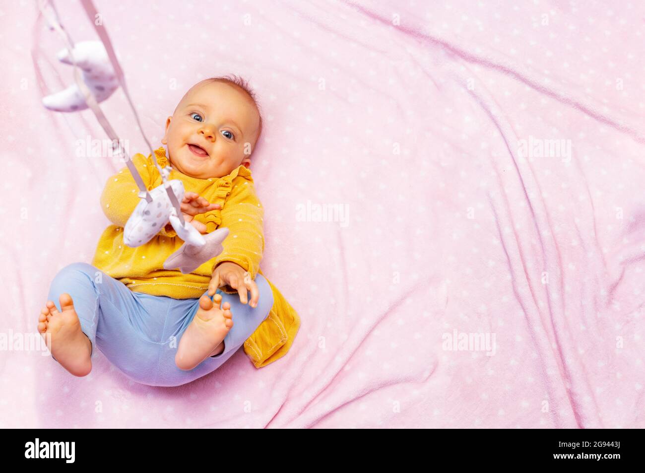 Little baby girl play with mobile toys from above Stock Photo - Alamy