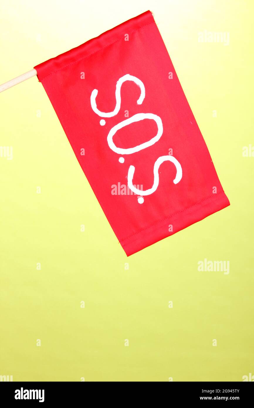 SOS signal written on red cloth on green background Stock Photo - Alamy