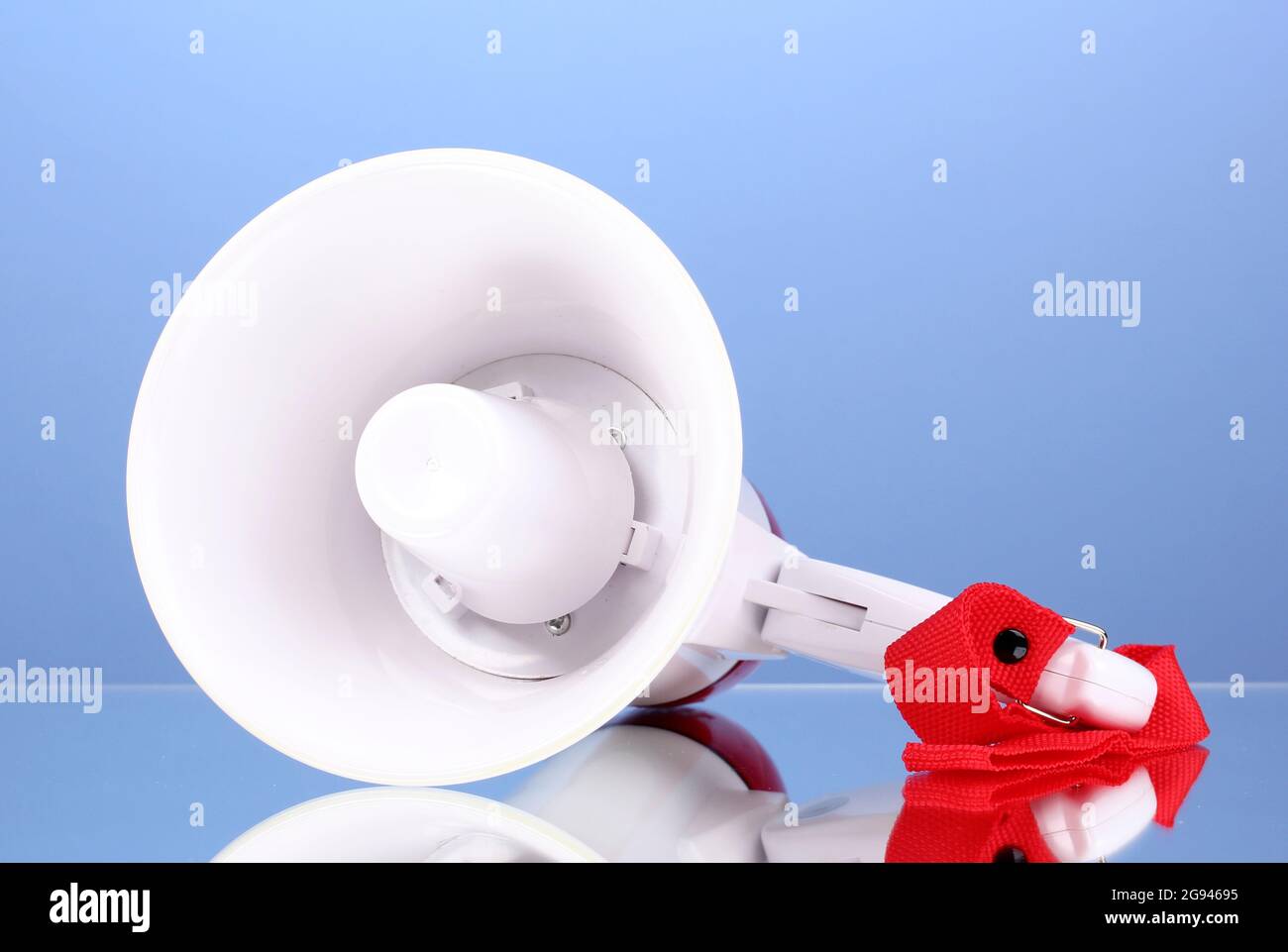 red and white megaphone on blue background Stock Photo - Alamy