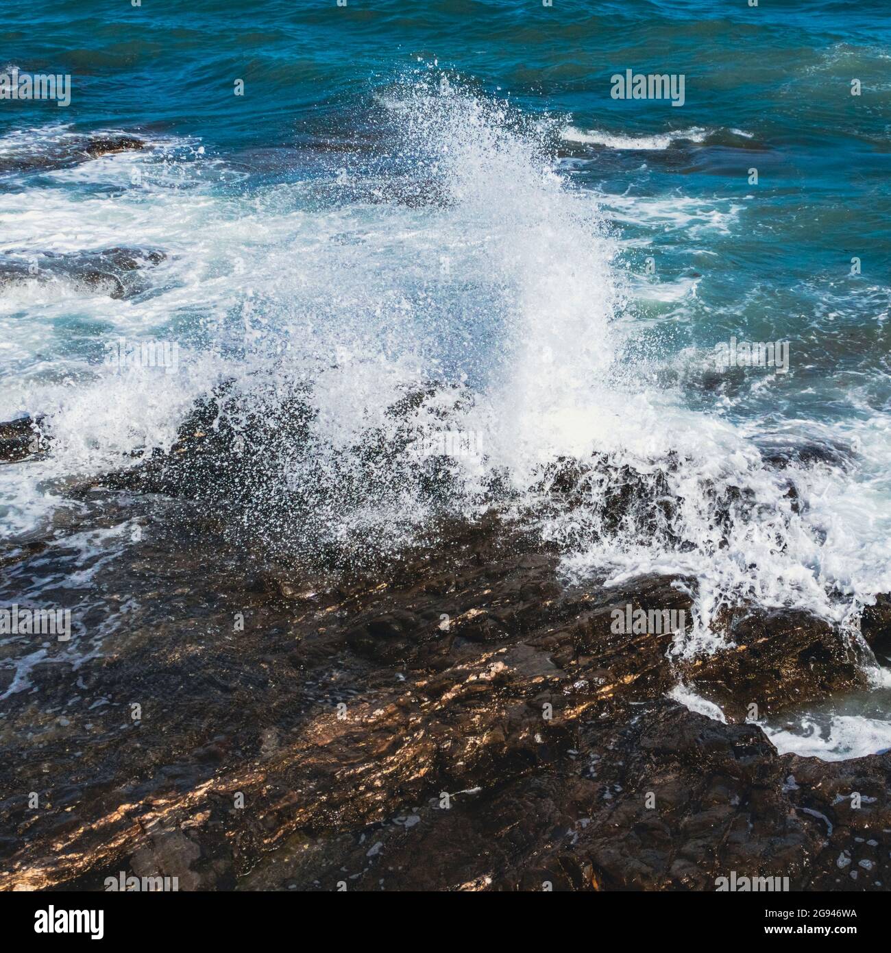Wave breaking on rock Stock Photo - Alamy