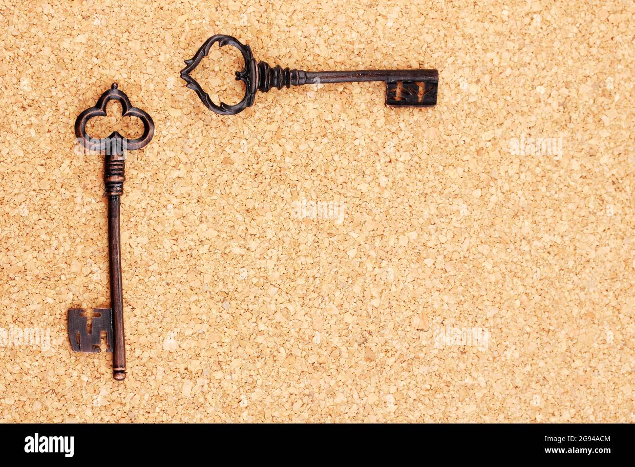 Two antique keys on cork background Stock Photo - Alamy