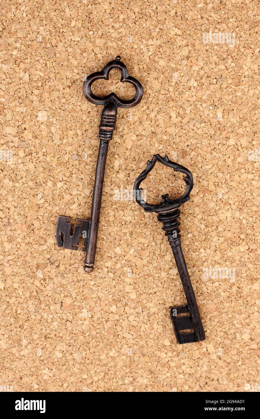 Two antique keys on cork background Stock Photo - Alamy