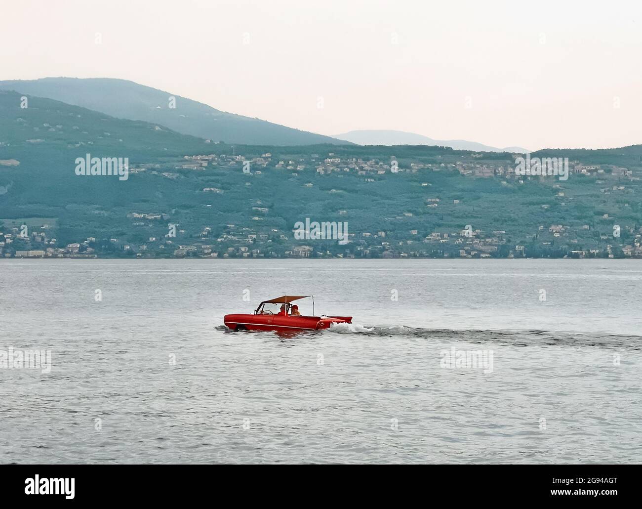 red amphibious car floats in the lake of a small town in France Stock ...