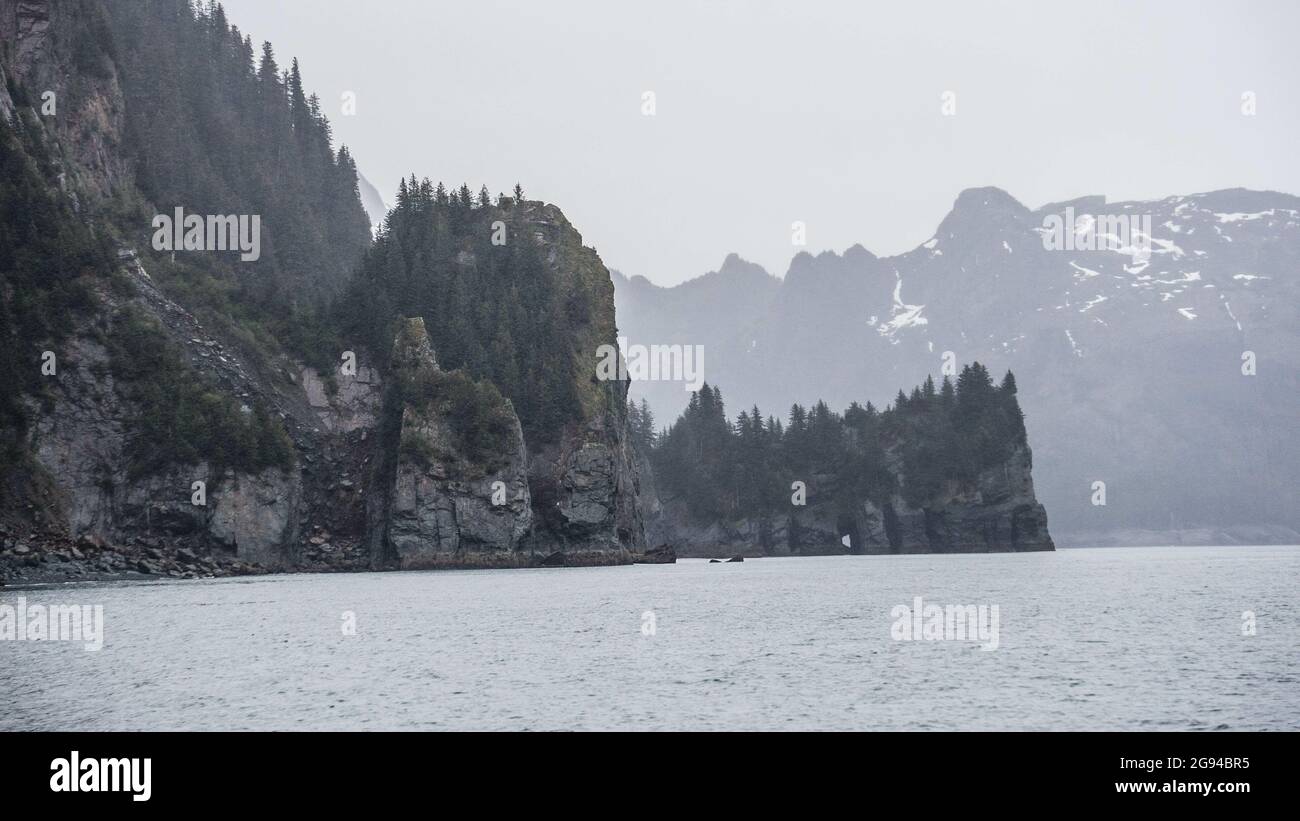 Lake with green cliffs under cloudy sky Stock Photo - Alamy
