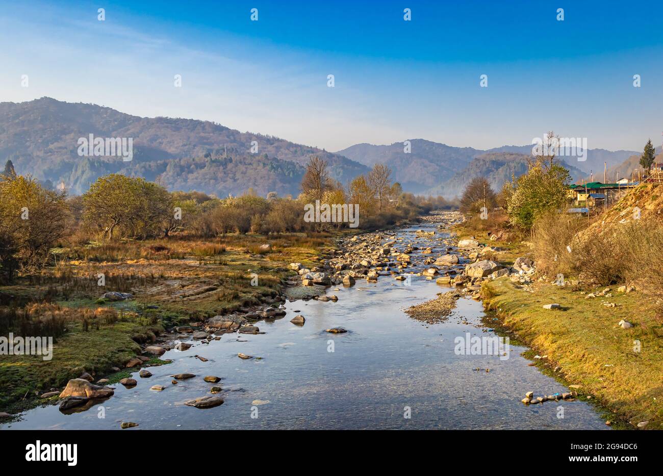 river flowing through misty mountain valley covered with dense forests ...