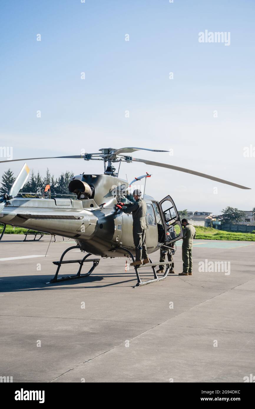 Three military men cleaning a helicopter in the sunlight Stock Photo ...