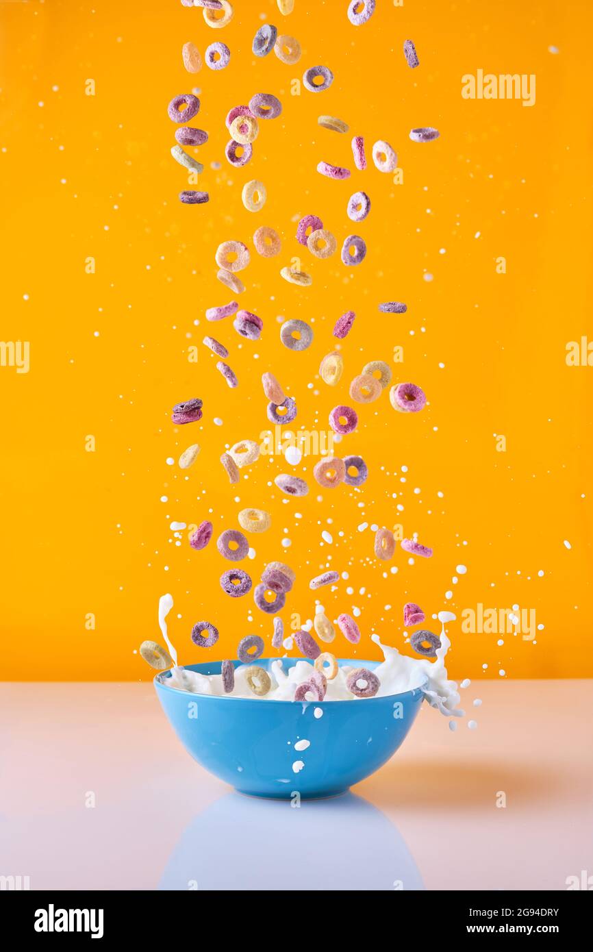 Cereal rings falling in milk bowl Stock Photo - Alamy