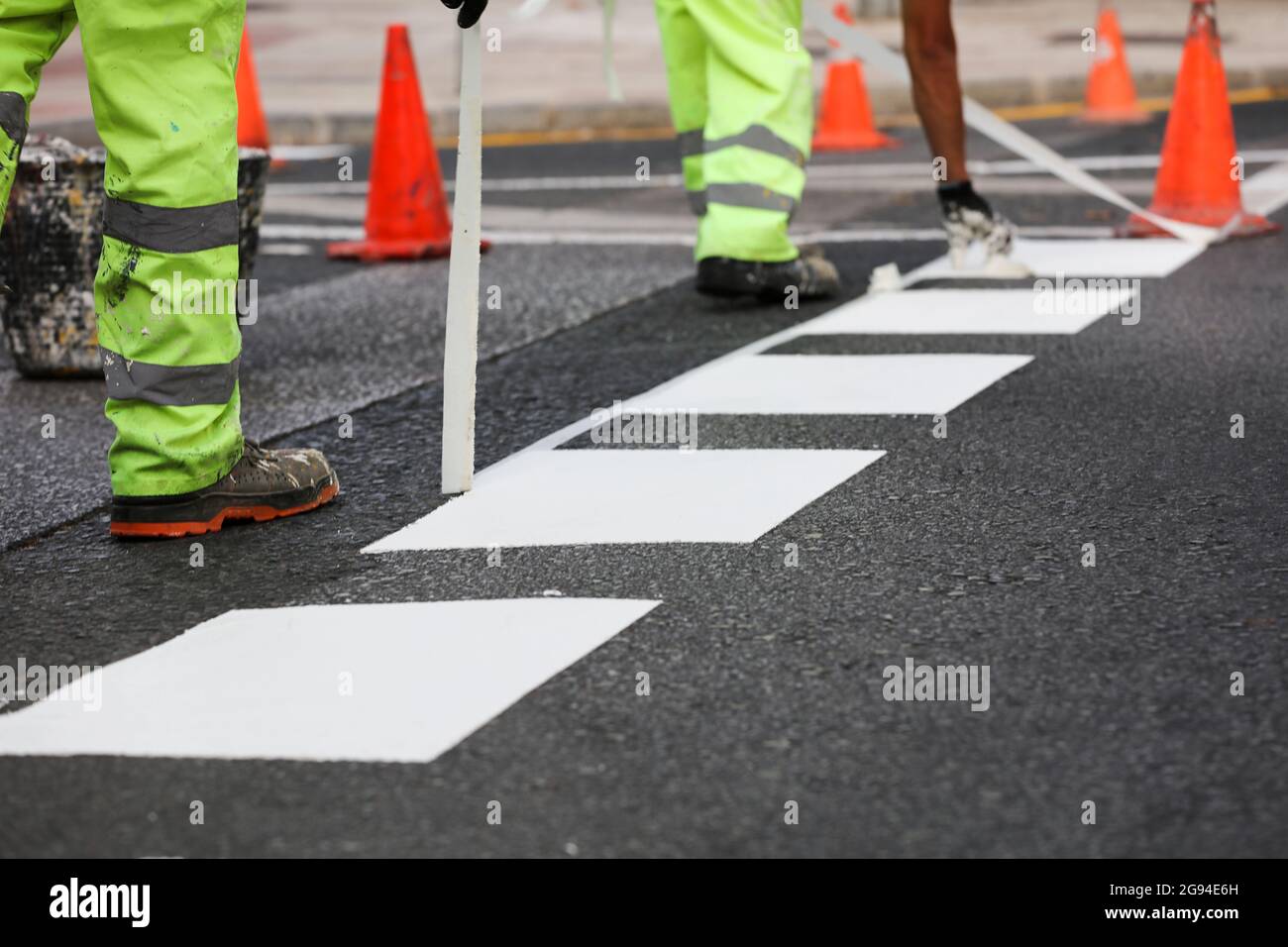 Painting the traffic line. Workers are painting white lines on the ...