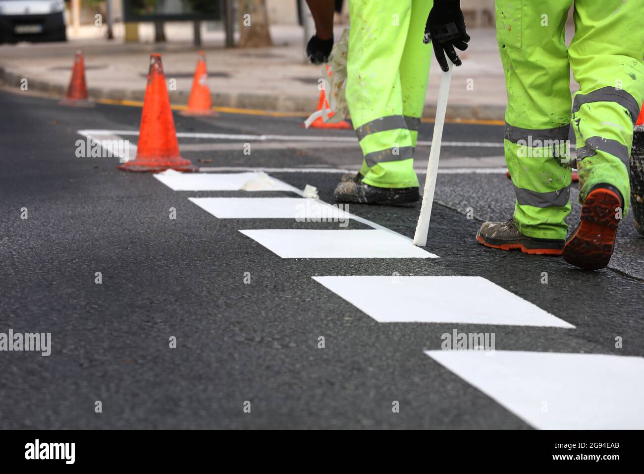 Painting the traffic line. Workers are painting white lines on the ...