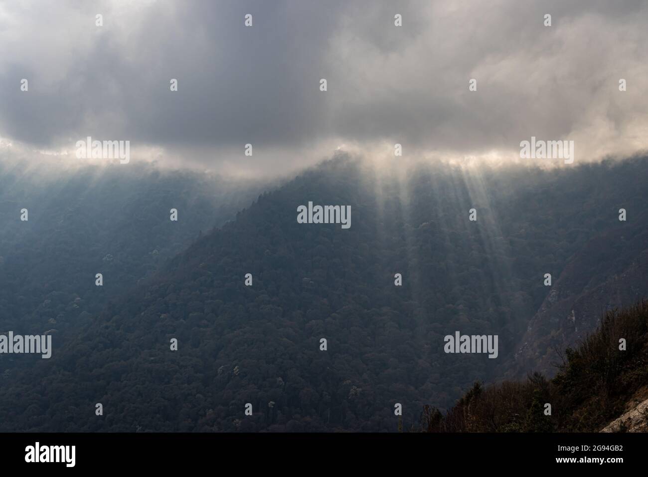 mountain range with sun ray beams and heavy cloud overcast at day Stock ...