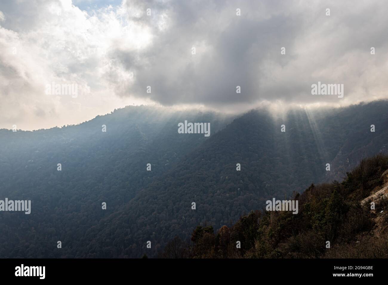 mountain range with sun ray beams and heavy cloud overcast at day Stock ...