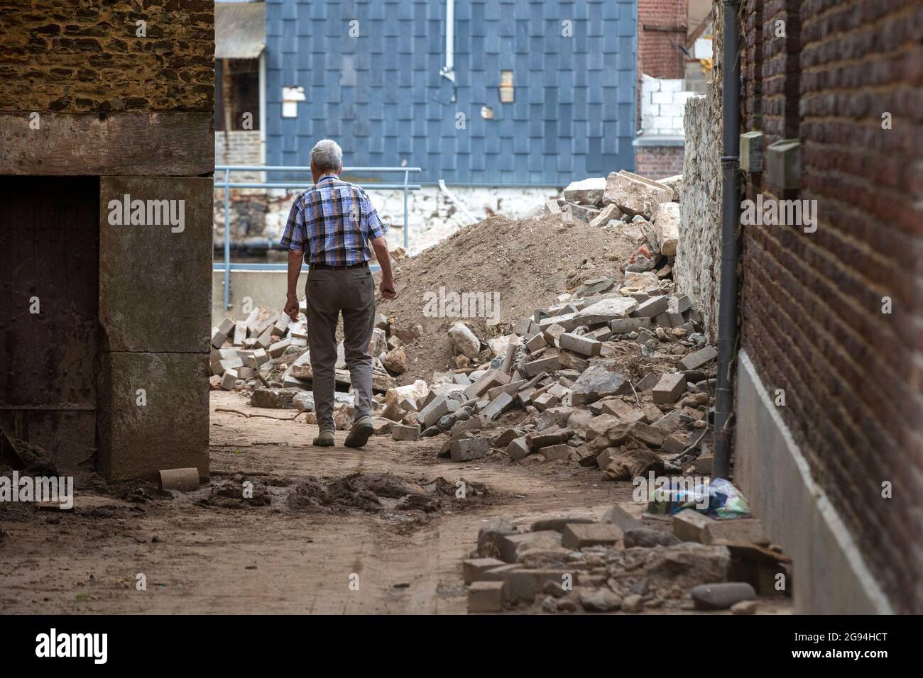 Illustration shows a man walking by piles of rubble and debris, at a ...