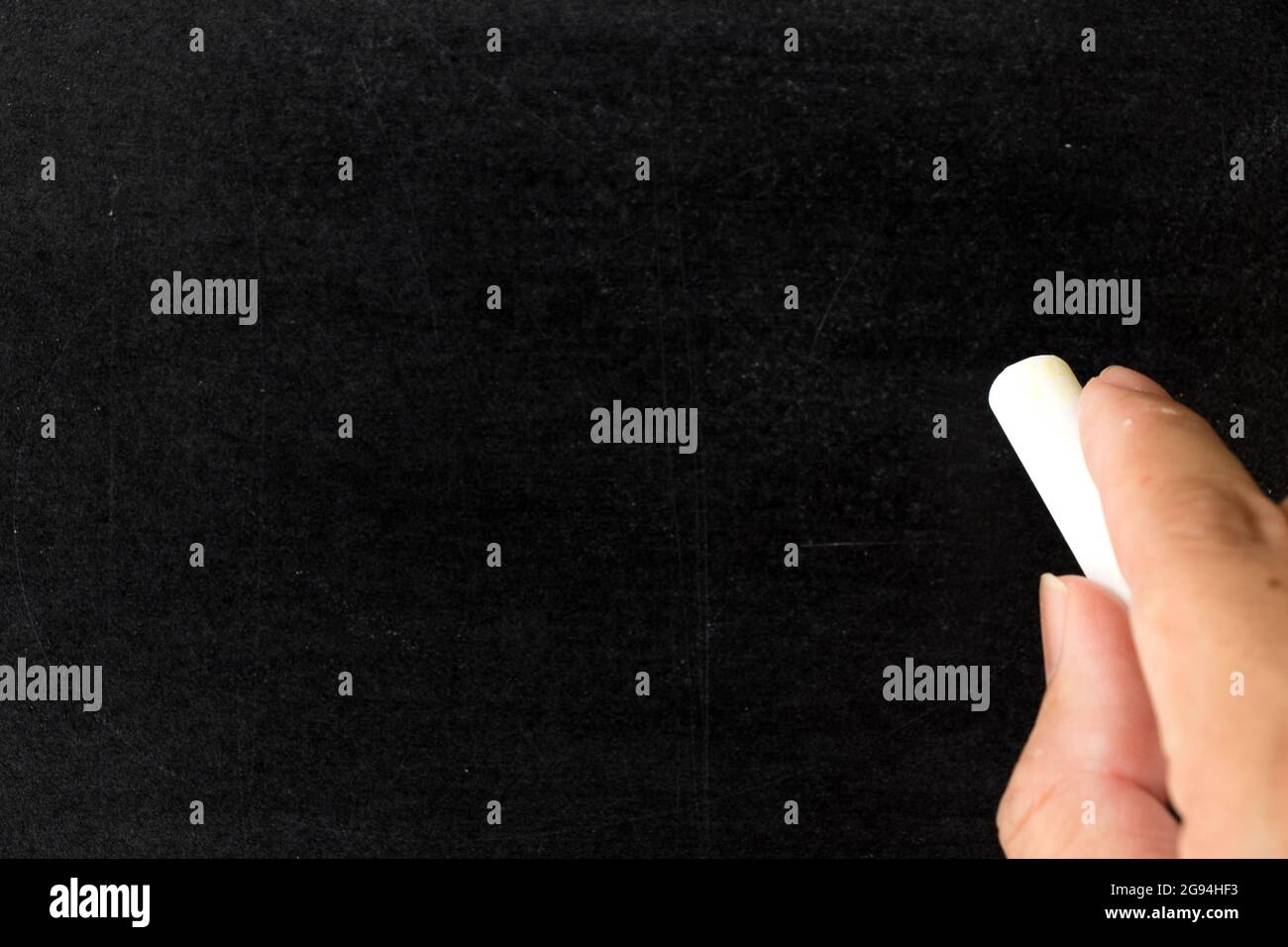 Hand hold white chalk on blackboard textured background Stock Photo - Alamy