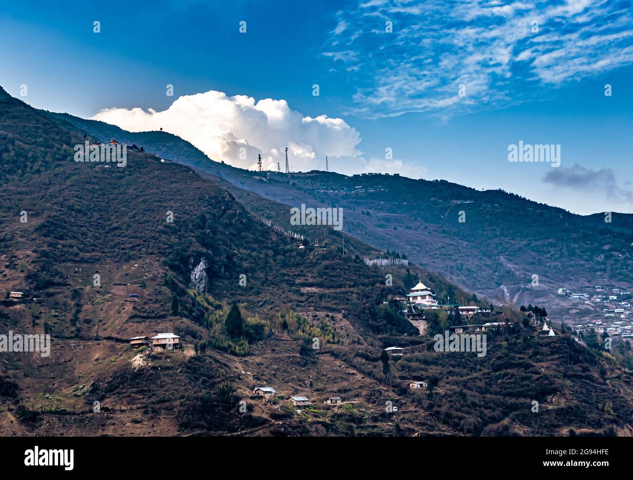Buddhist monastery situated at mountain foothill with bright blue sky ...