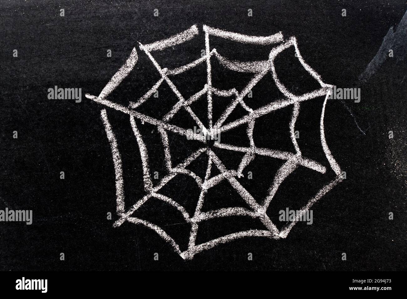 White chalk hand drawing in spiderweb shape on blackboard background ...