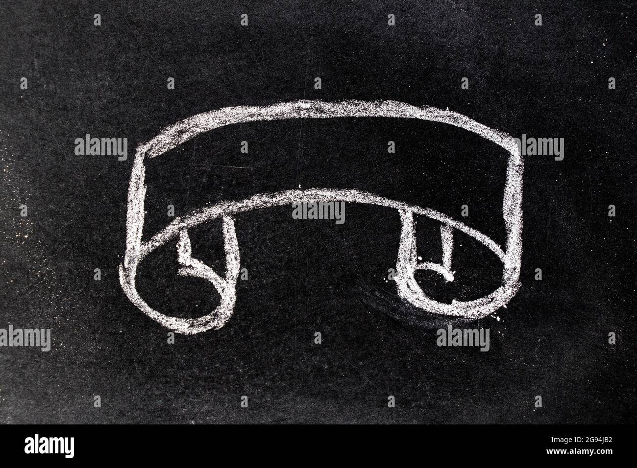 White chalk hand drawing in blank scroll banner shape on blackboard ...