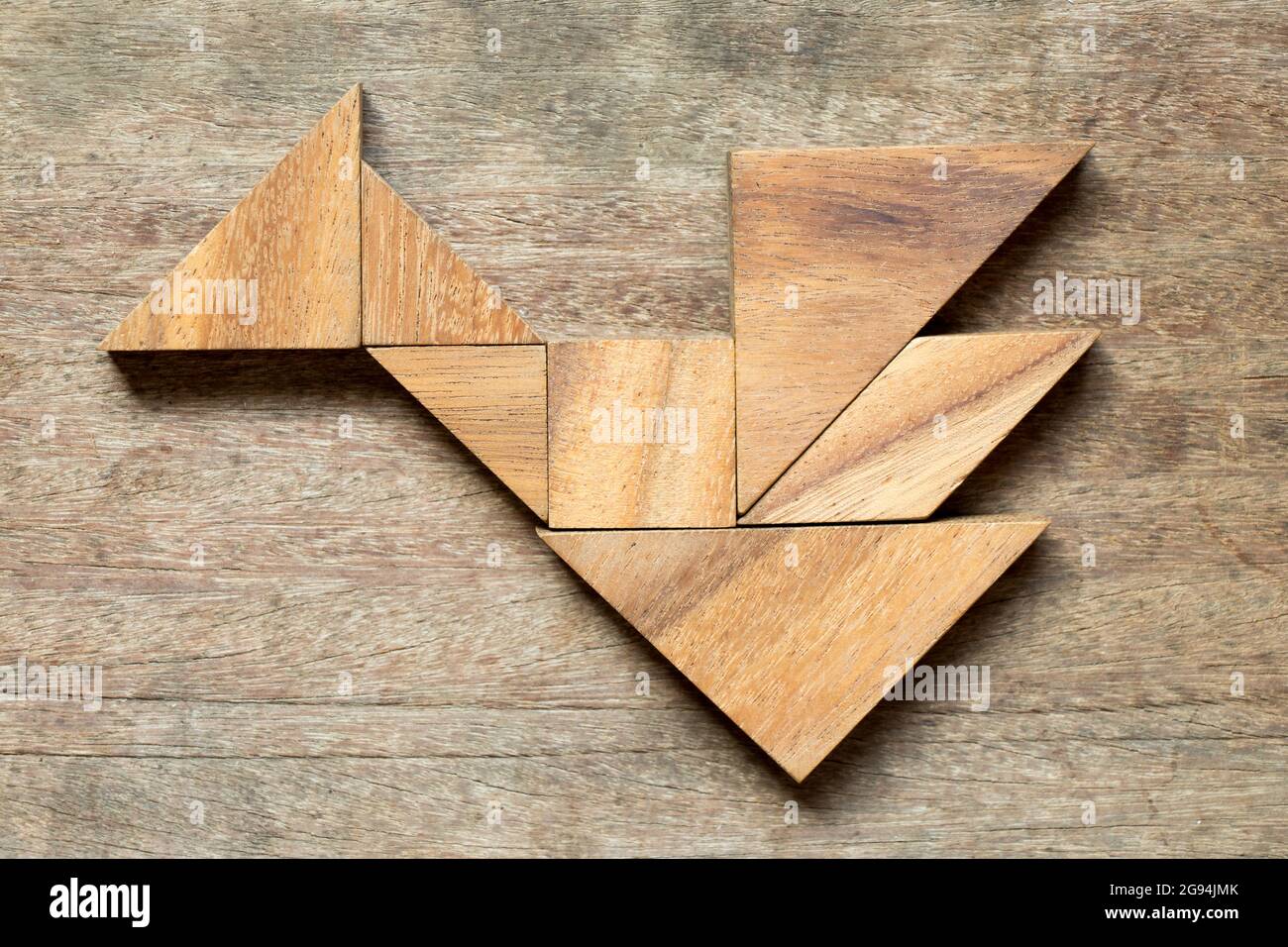 Tangram puzzle in bird or dragon shape on wood background Stock Photo ...