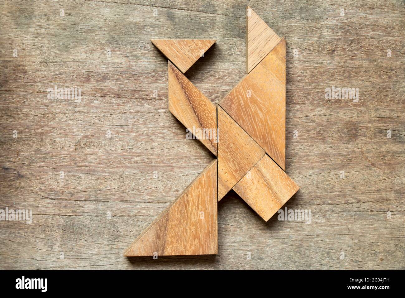 Tangram puzzle in flying bird or dragon shape on wood background Stock ...