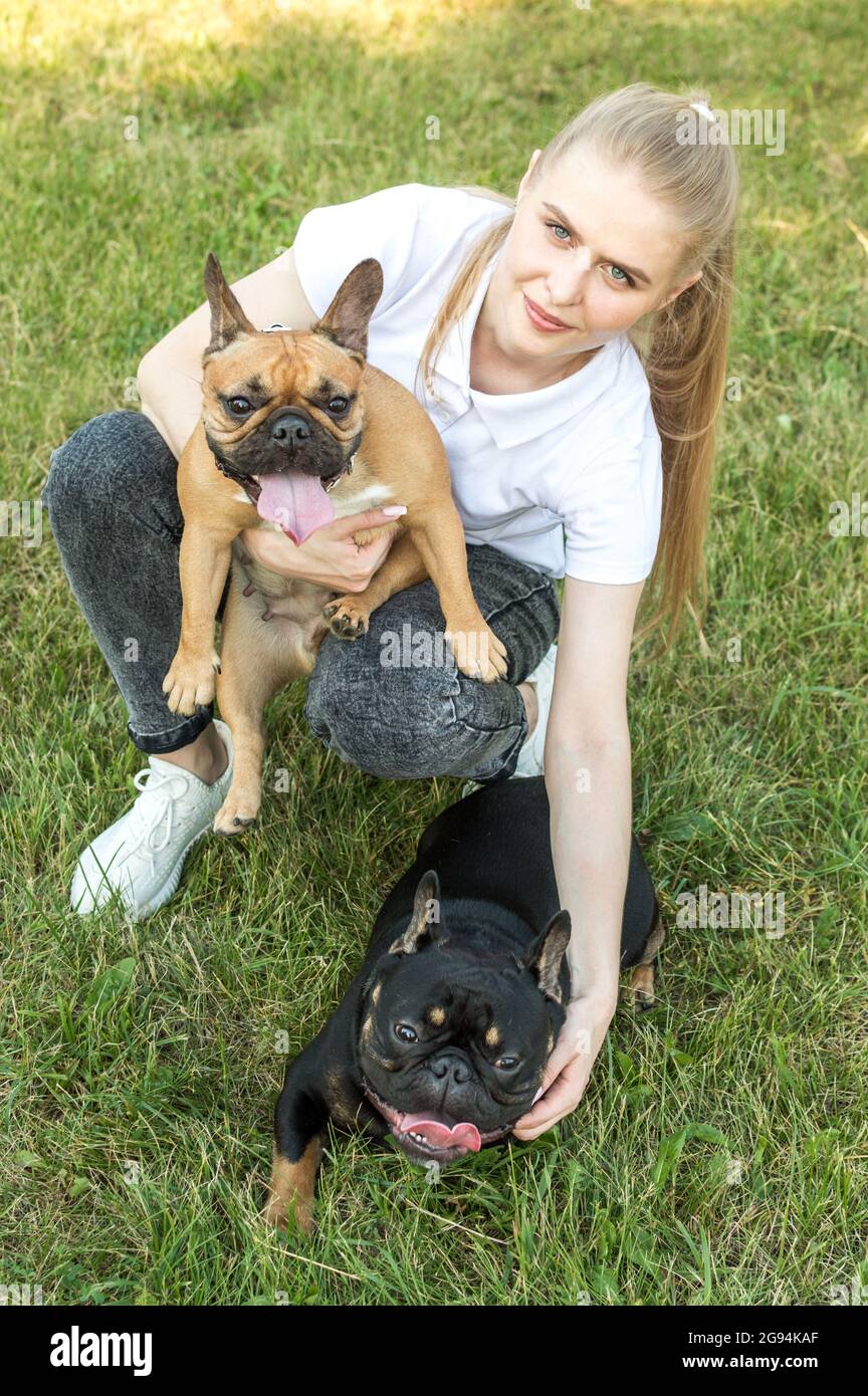 Young woman with two dogs for a walk in the park. Vertical photo Stock ...