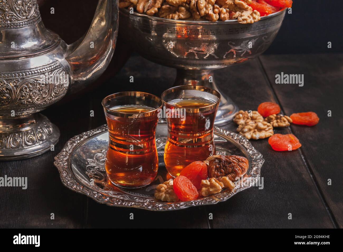 Plate with tea in armuda glasses, vintage jug, a vase with dried fruit ...