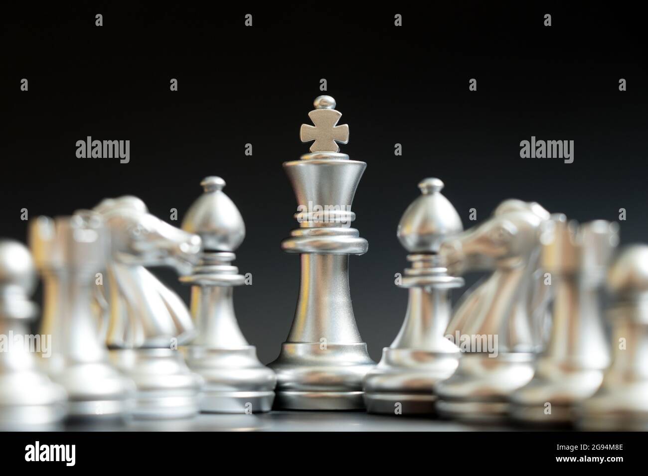 Silver king chess piece stand with bishop, knight, rook, pawn on black ...