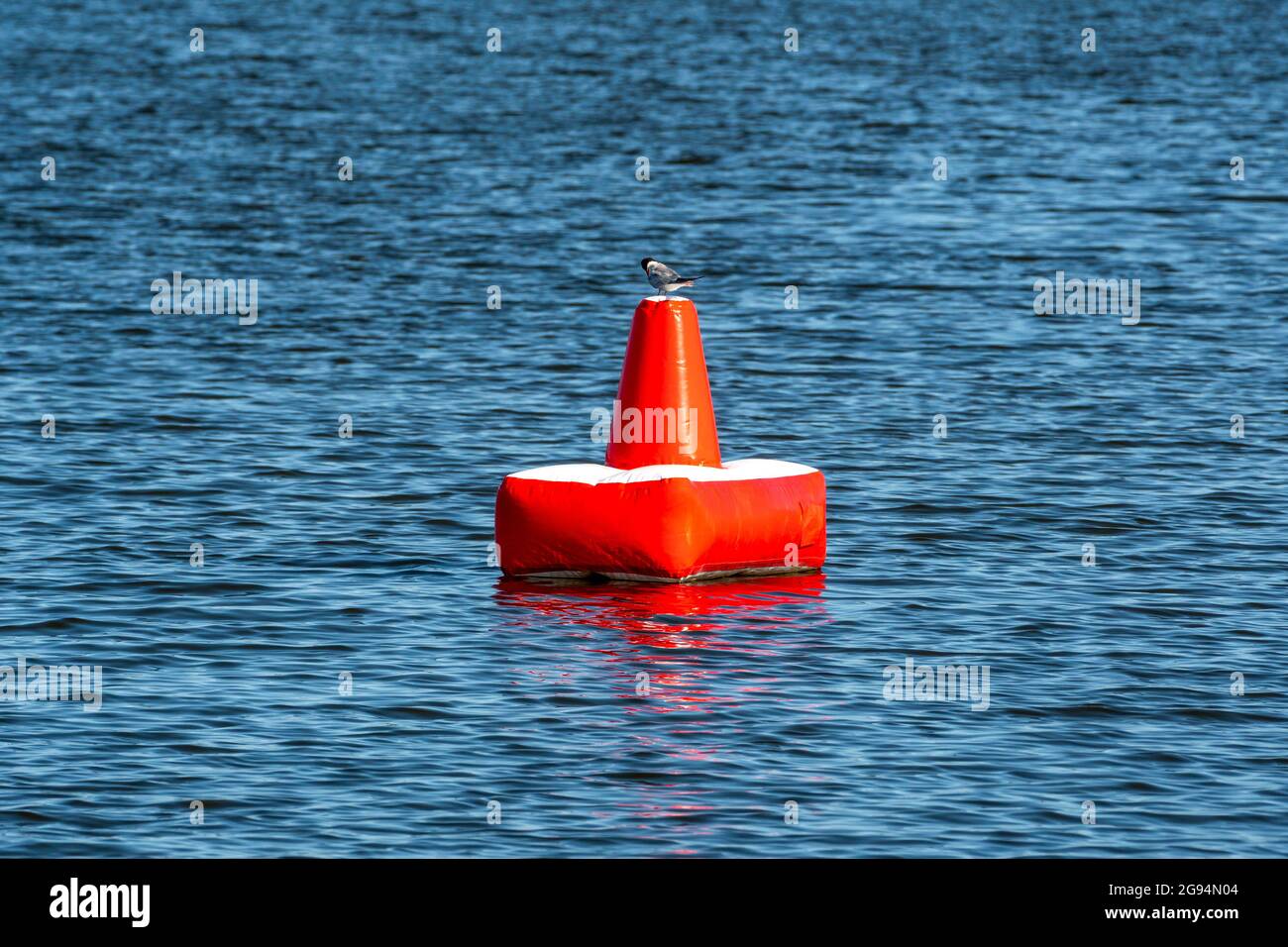 Red inflatable buoy on the blue sea. A buoy is a floating device that ...