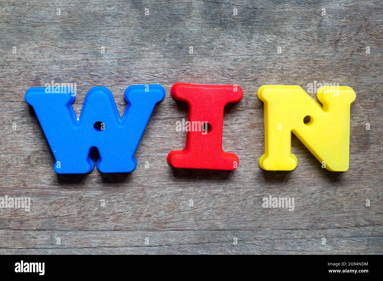 Color alphabet in word win on wood background Stock Photo - Alamy