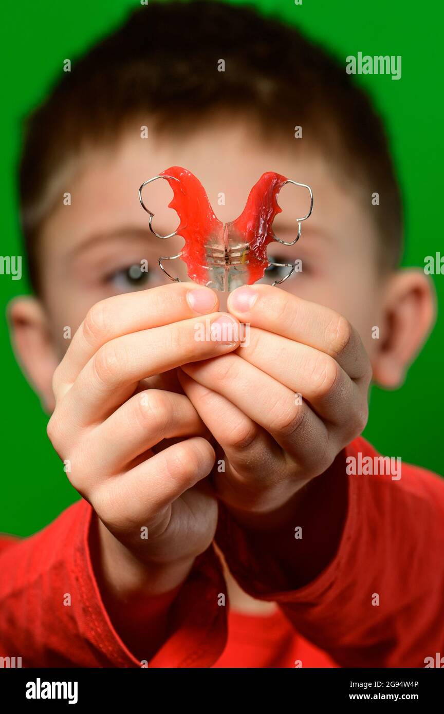 Dental plate to align deformed teeth, the boy holds his dental floss in ...