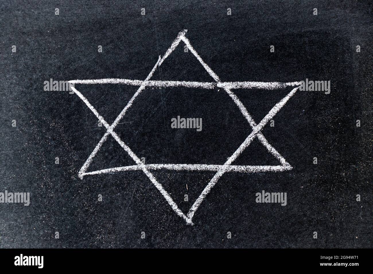 White chalk drawing in star of david shape on black board background ...