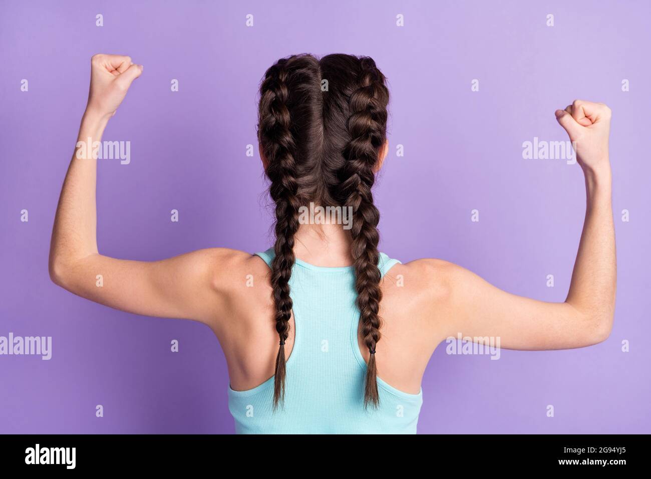 Rear back behind view portrait of attractive strong girl demonstrating ...