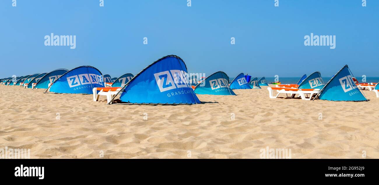 Summertime along the North Sea coast: Colorful windbreaks on the beach ...