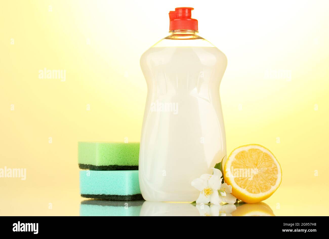 Dishwashing liquid with sponges and lemon with flowers on yellow ...