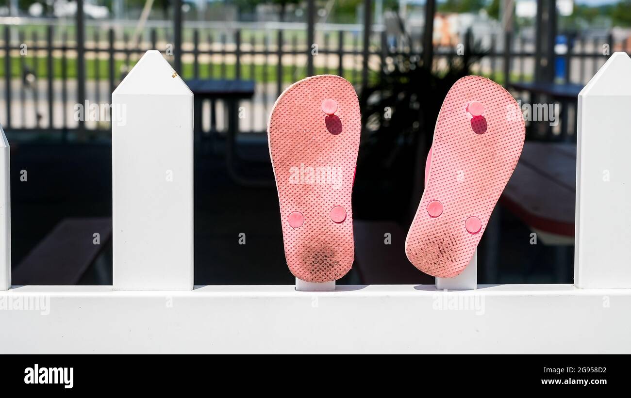 Pink flip flops outside on white fence Stock Photo - Alamy