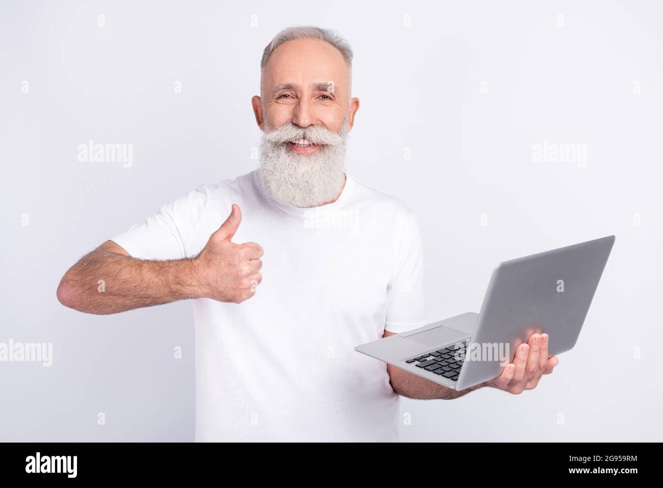 Photo of positive happy charming old man hold computer laptop show ...