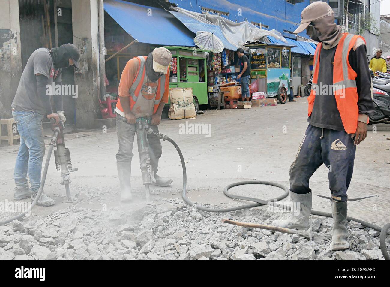 Construction workers are using jack hammer tools to destroy the street ...