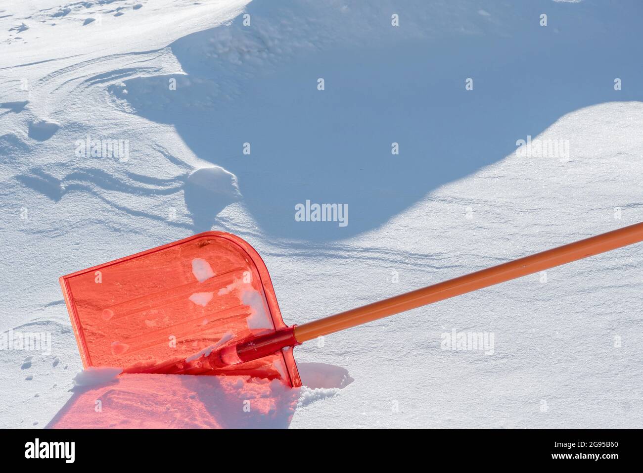 A snow shovel is stuck in a snowdrift in winter in winter. Snow removal ...