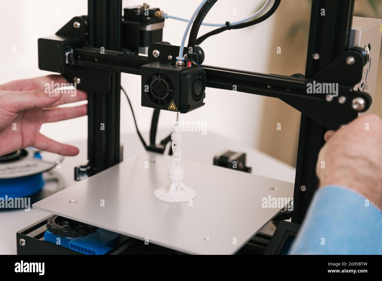Young engineer in the lab adjusting a 3D printer's components Stock ...
