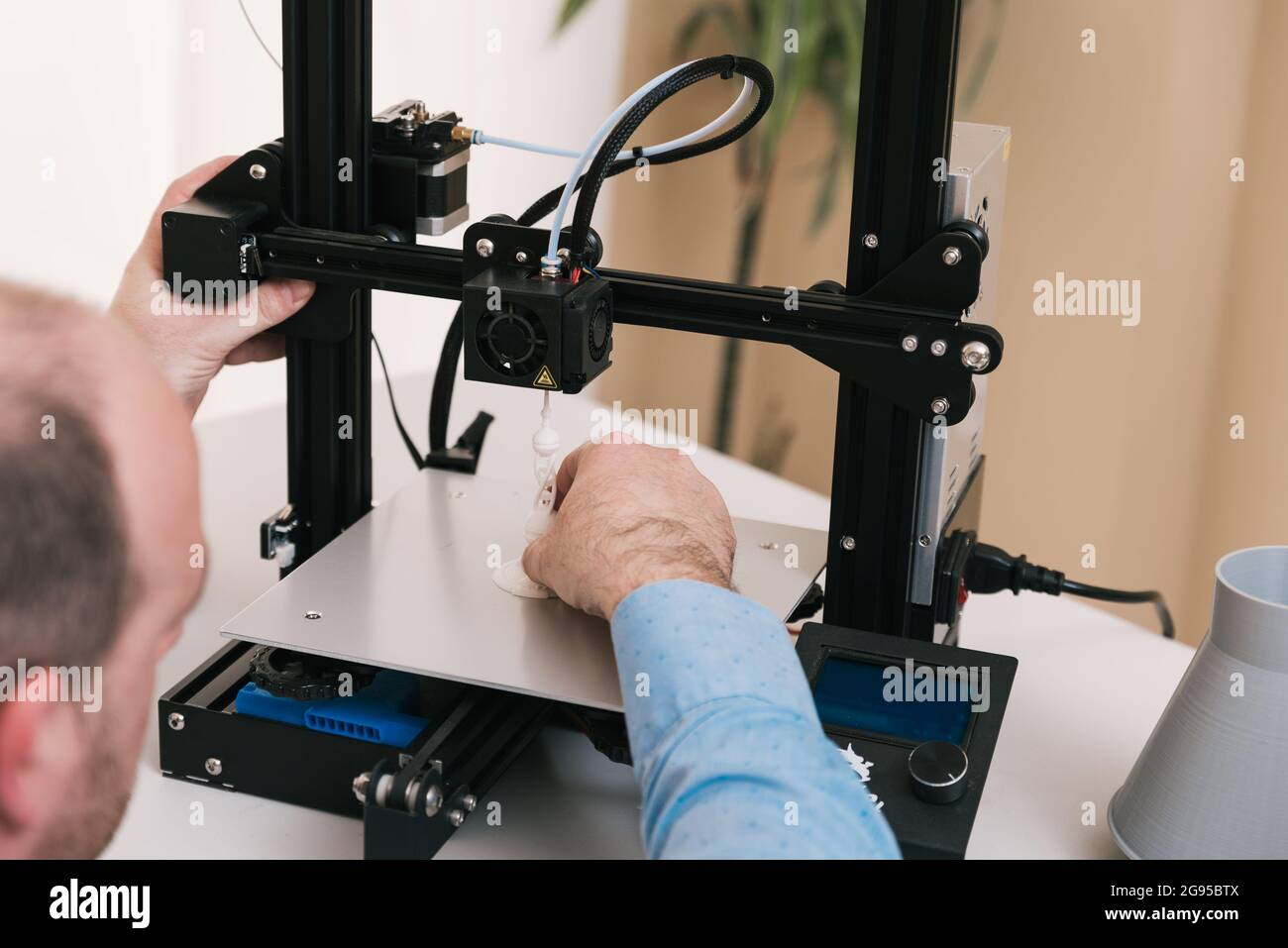 Young engineer in the lab adjusting a 3D printer's components Stock ...