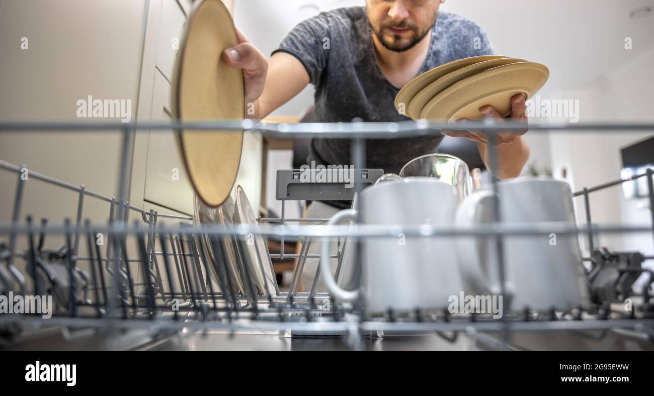 Man puts plate dishwasher hi-res stock photography and images - Alamy