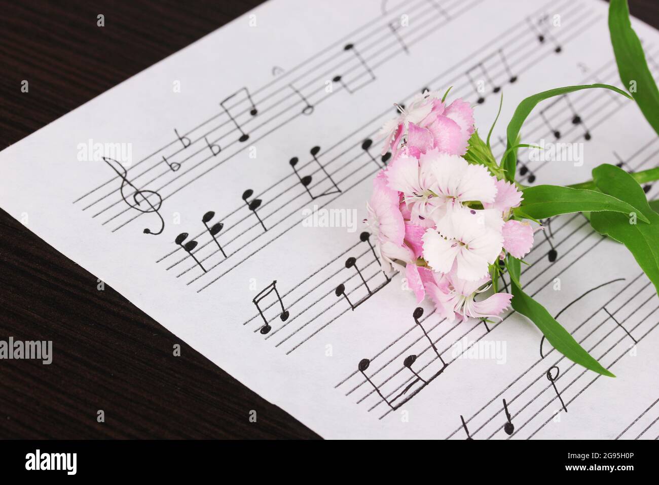 Musical notes and flower on wooden table Stock Photo - Alamy
