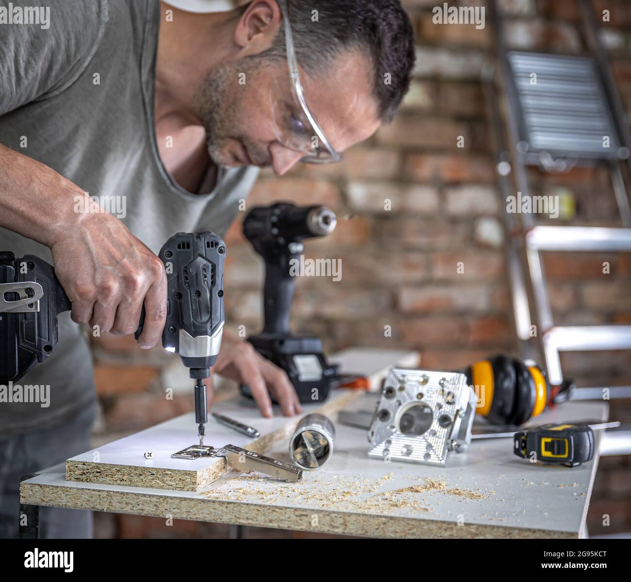 Screwing a self-tapping screw into a metal fastening hole on a wood ...