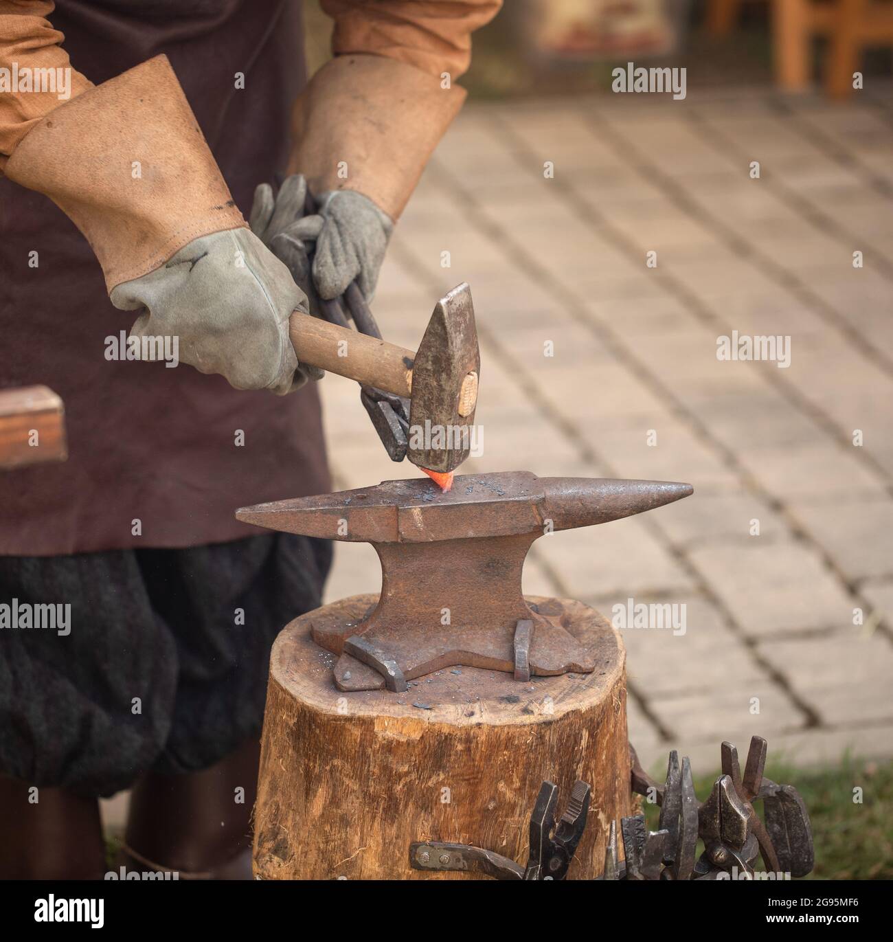 Blacksmith in medieval costume recreates the ancient craft of ...