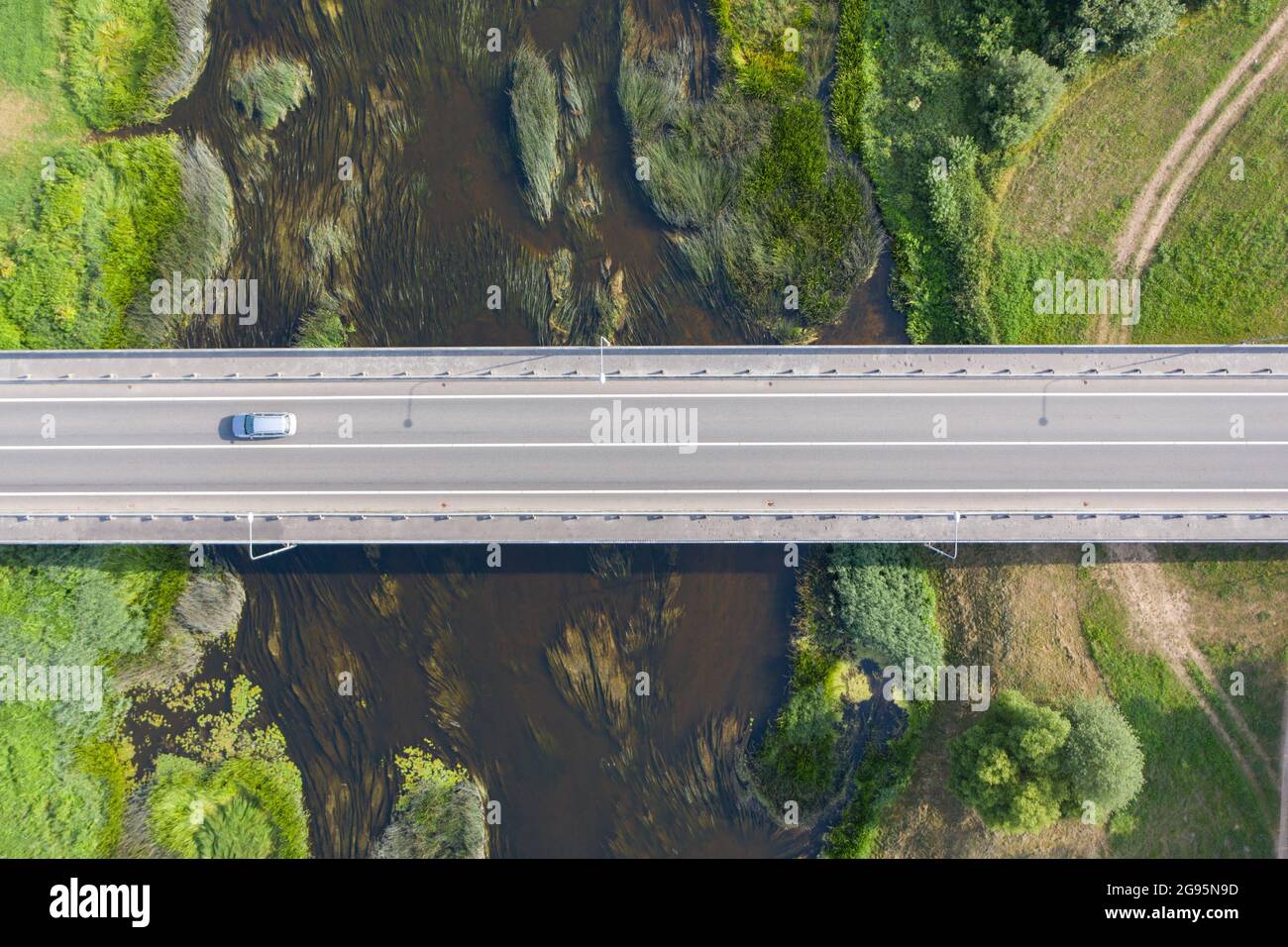 Aerial top down view of car driving over bridge. River flowing under ...