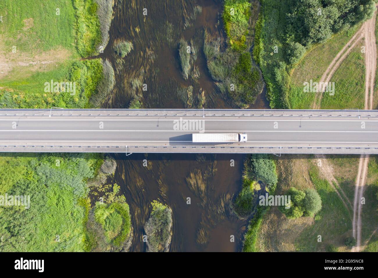 Aerial top down view of truck driving over bridge. River flowing under ...