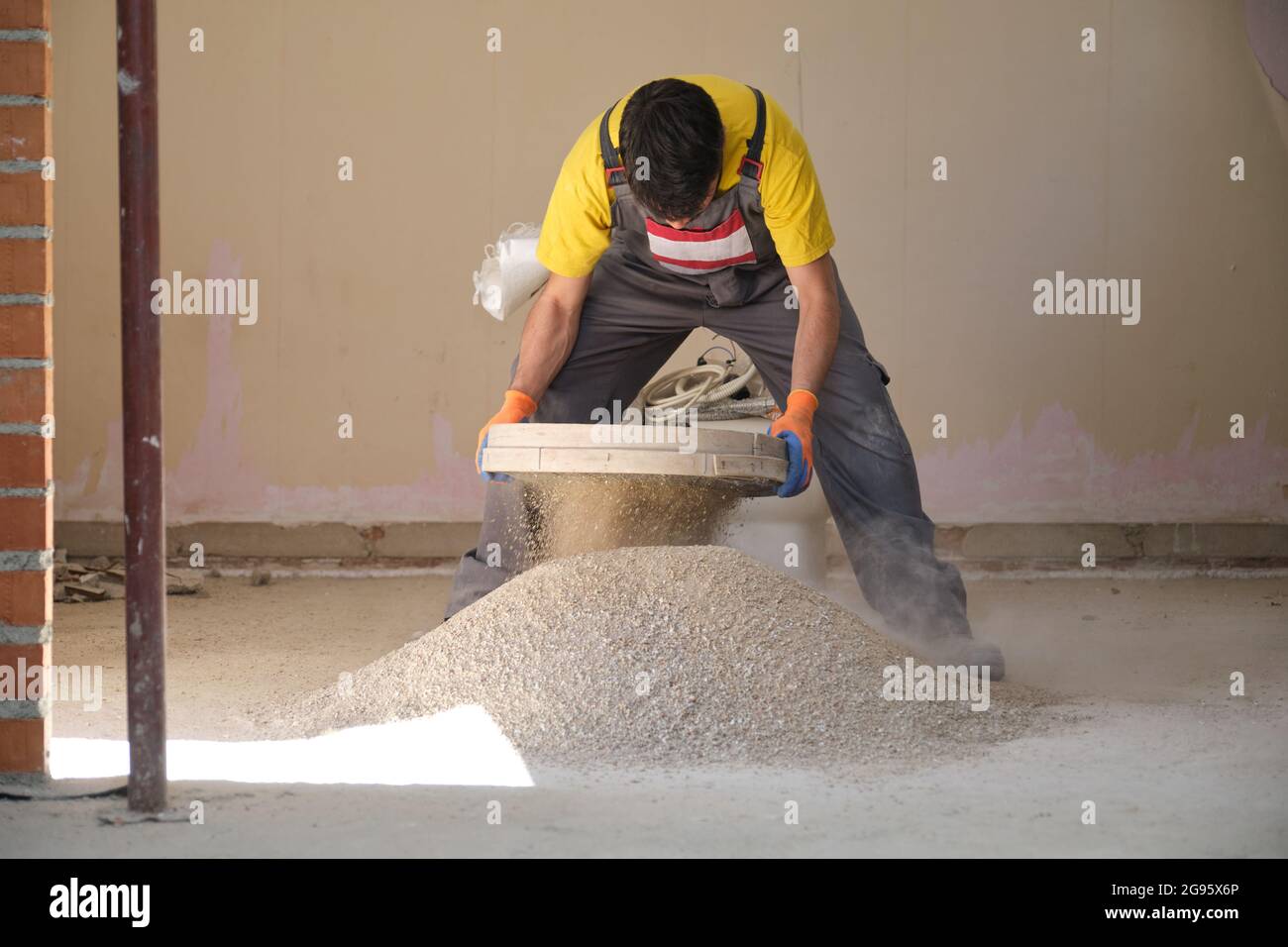 Young caucasian construction worker sieving sand during a house ...
